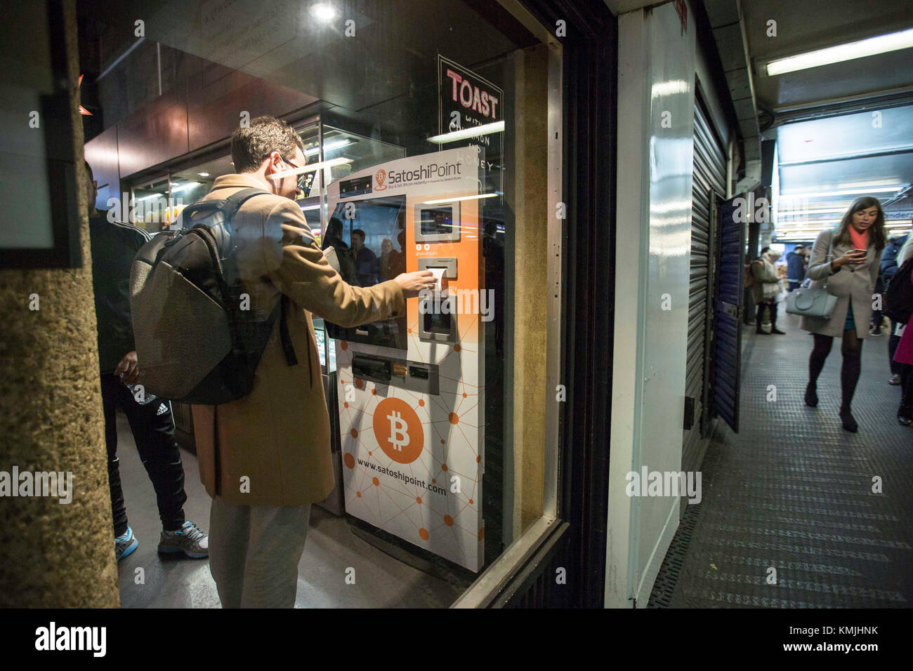 A customer uses a Bitcoin machine in Old Street underground station in ...