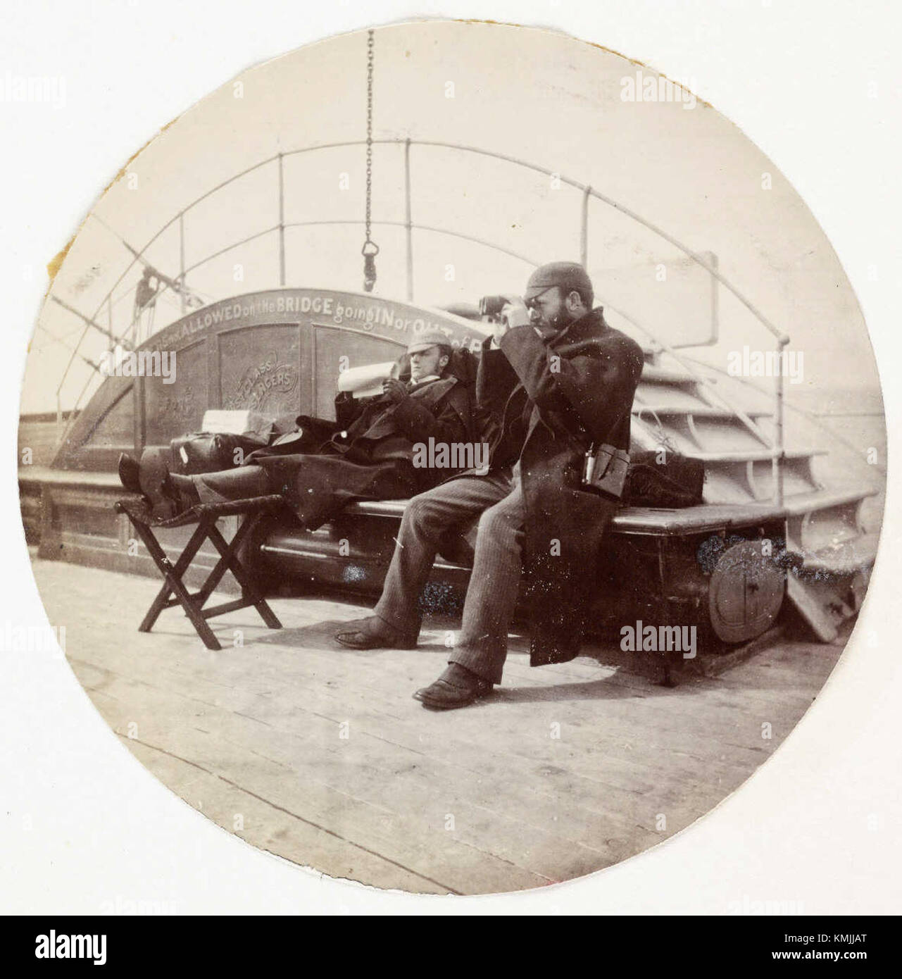 This image depicts two men standing on the deck of a ship. The scene ...