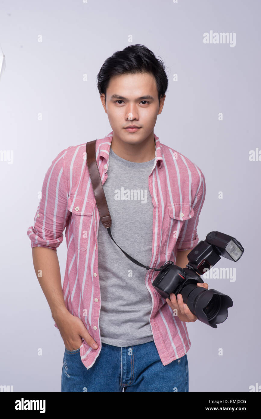 Young asian photographer holding digital camera, while working in ...