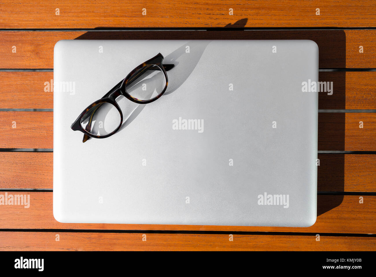 New modern metallic laptop and sight glasses with shadows outdoor on an ...