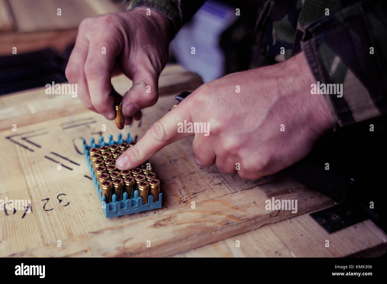 Soldier loading a 9mm caliber cartridge on a military shooting range ...