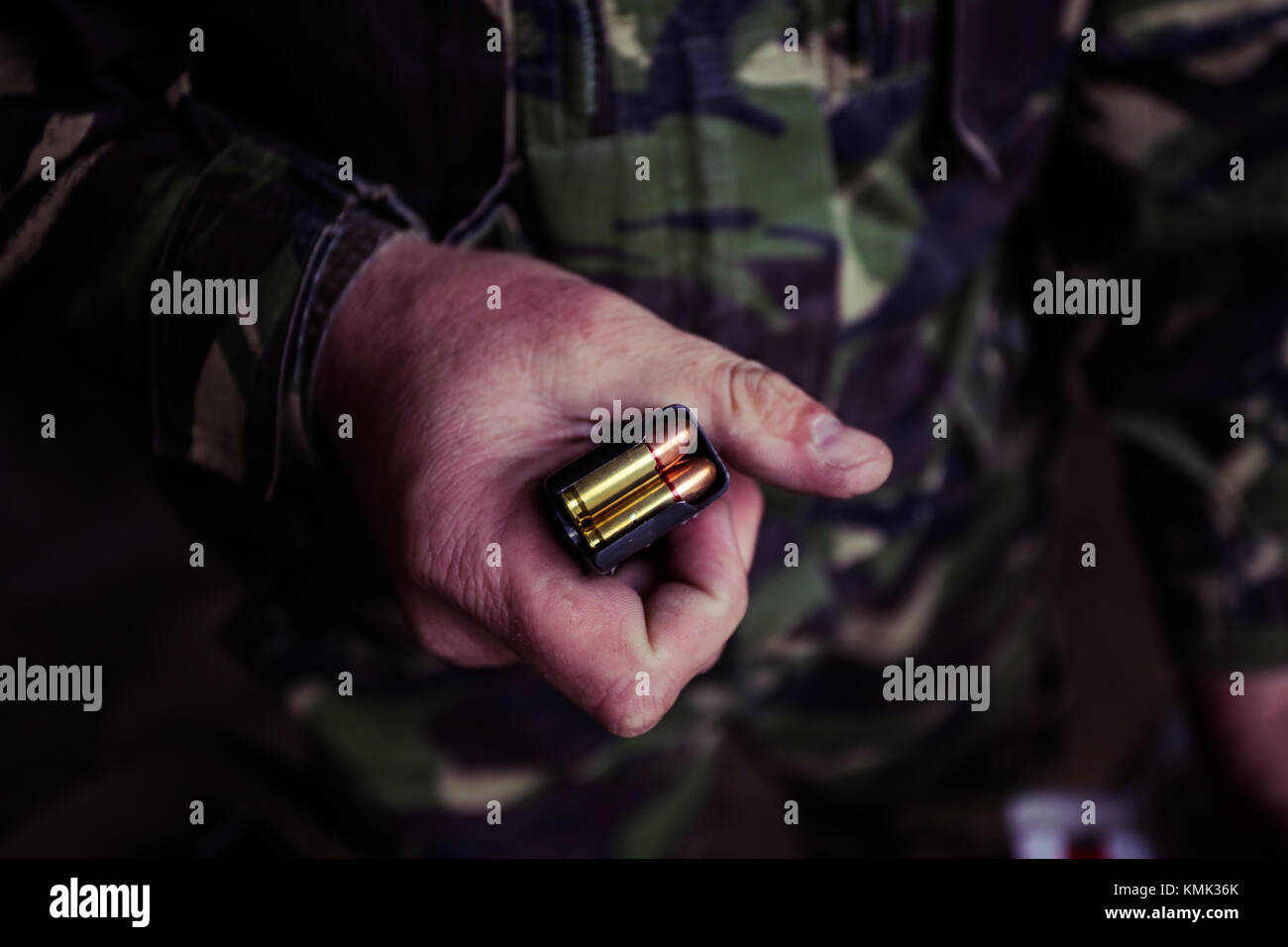 Soldier loading a 9mm caliber cartridge on a military shooting range ...