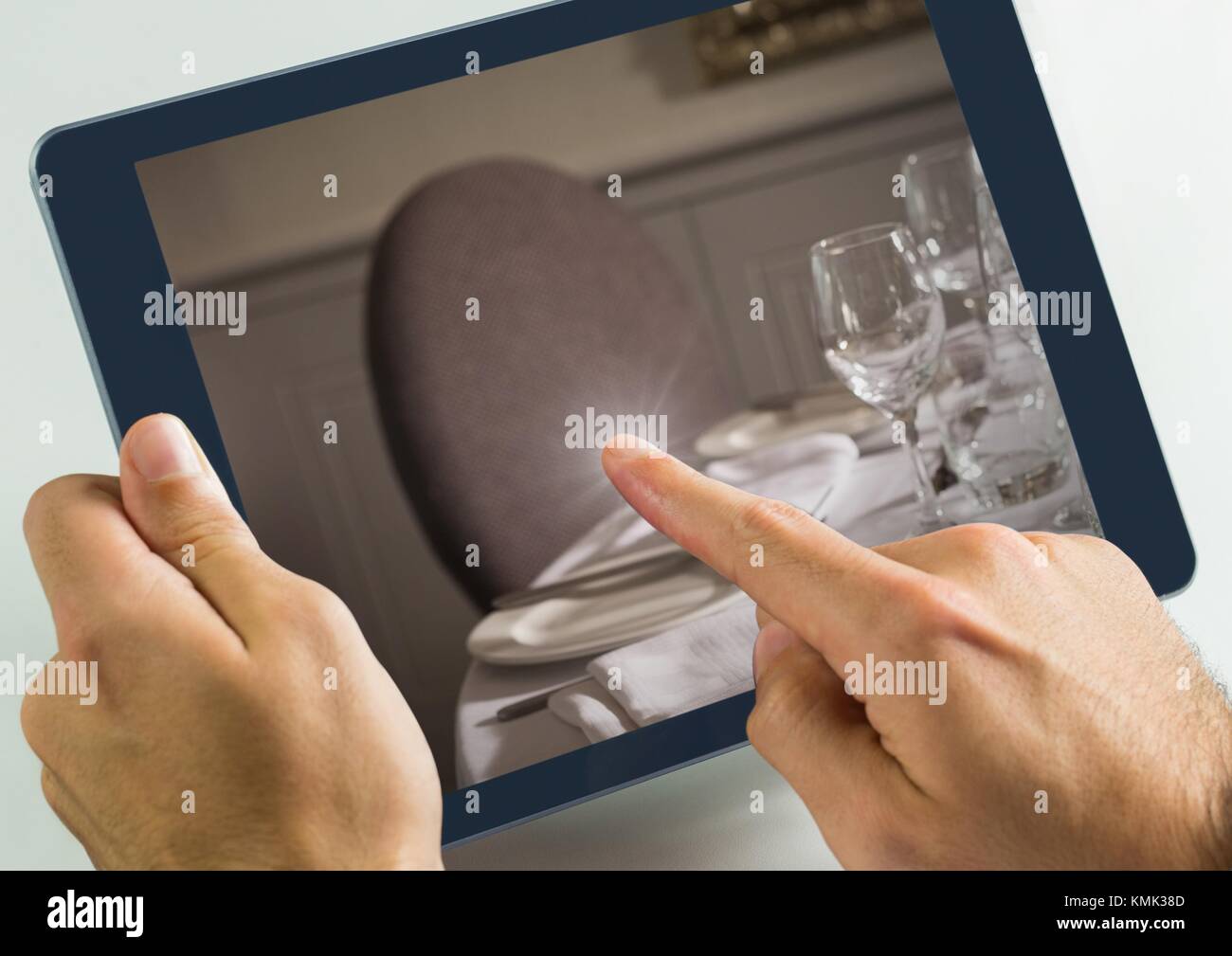Digital composite of Hand touching tablet with dinner table restaurant ...