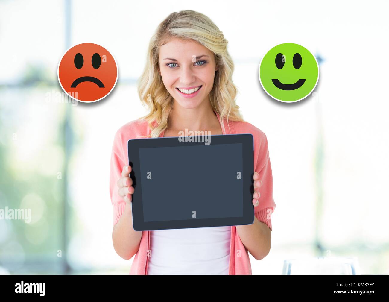 Digital composite of Woman holding tablet with feedback smiley face ...