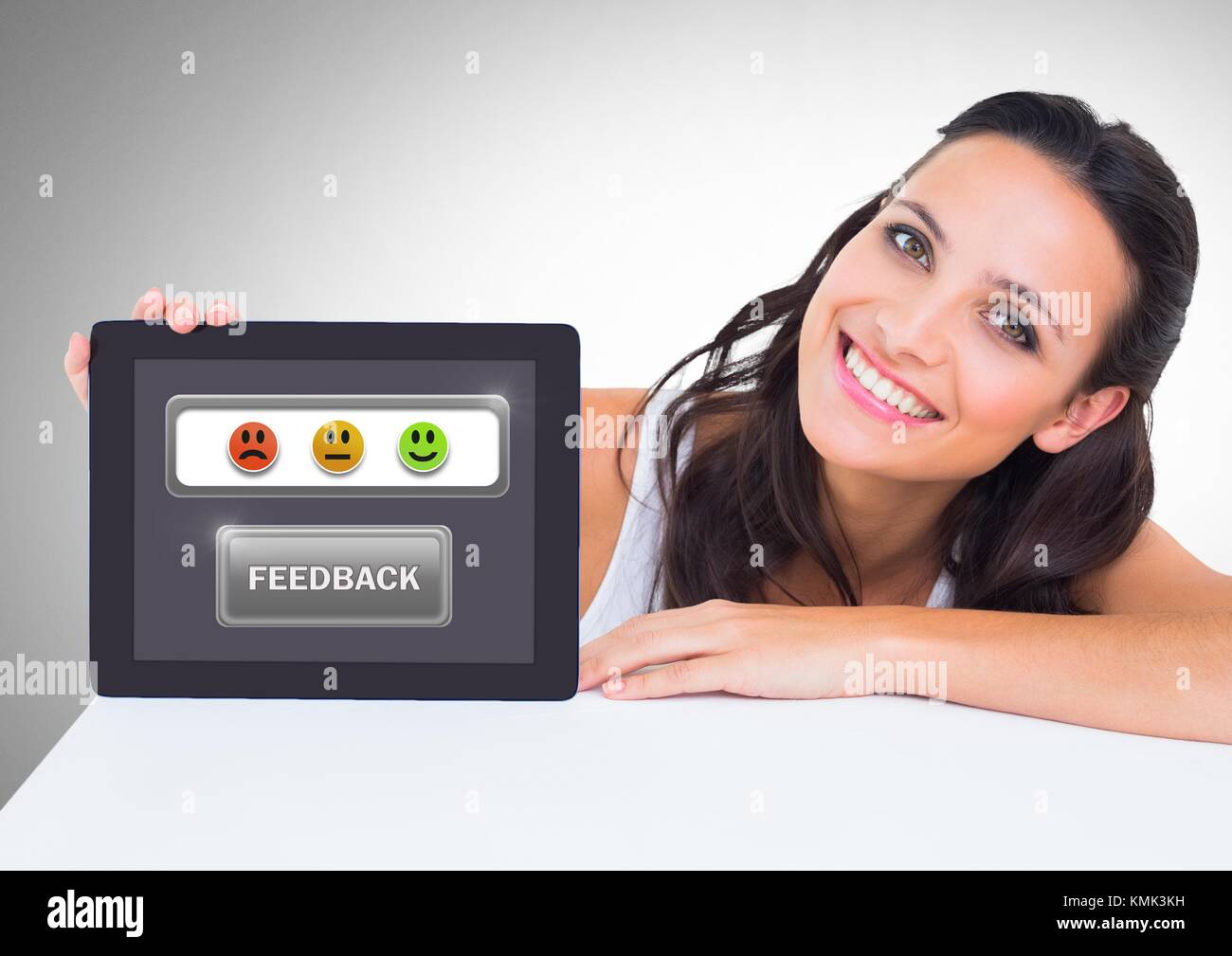 Digital composite of Woman holding tablet with feedback smiley ...