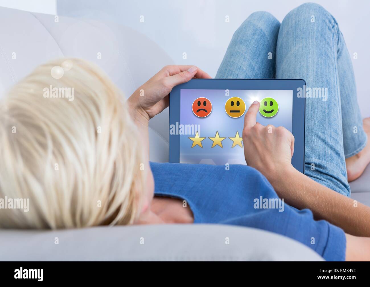 Digital composite of Woman touching tablet with feedback smiley face ...