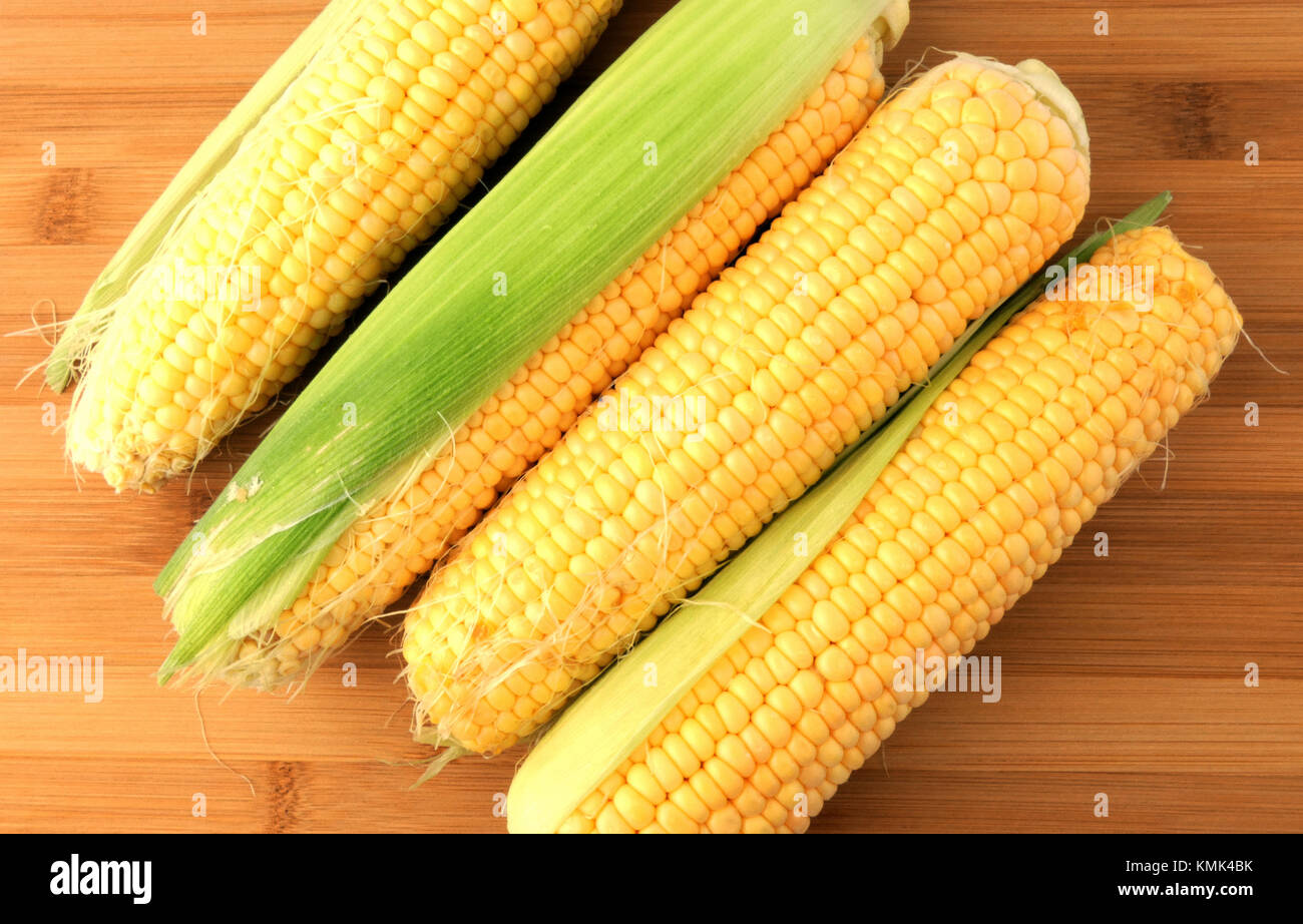 Corn cob on wooden plank isolated on white Stock Photo - Alamy