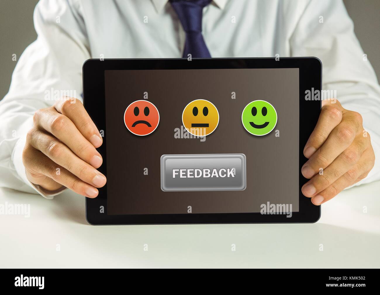 Digital composite of Hands holding tablet with smiley face feedback ...