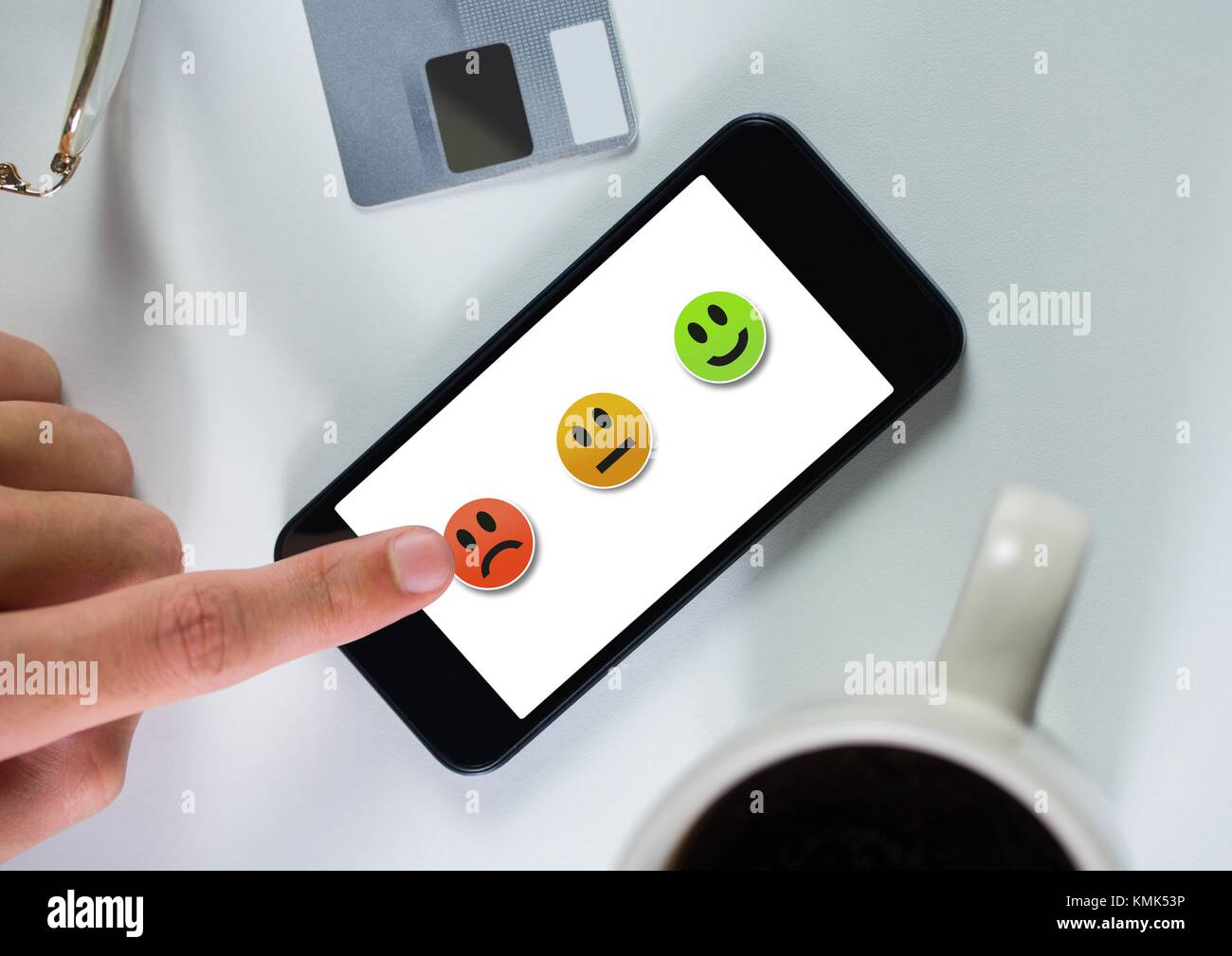Digital composite of Hand touching phone ith smiley feedback ...