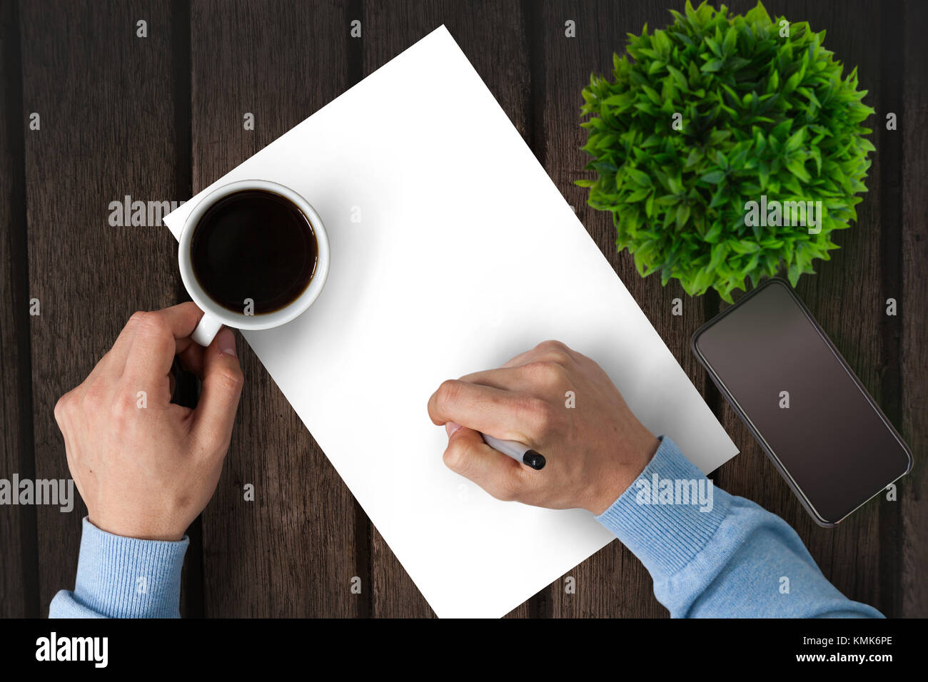 Man writing on paper while drinking coffee Stock Photo - Alamy