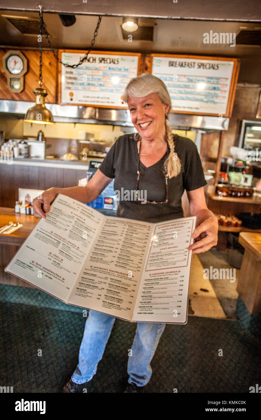 The friendly hostess of a Costa Mesa, CA, restaurant shows the menu to ...