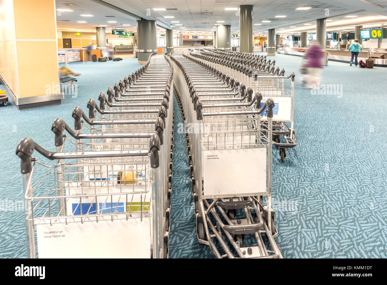 Even rows of empty trolleys for luggage in the building of a modern ...