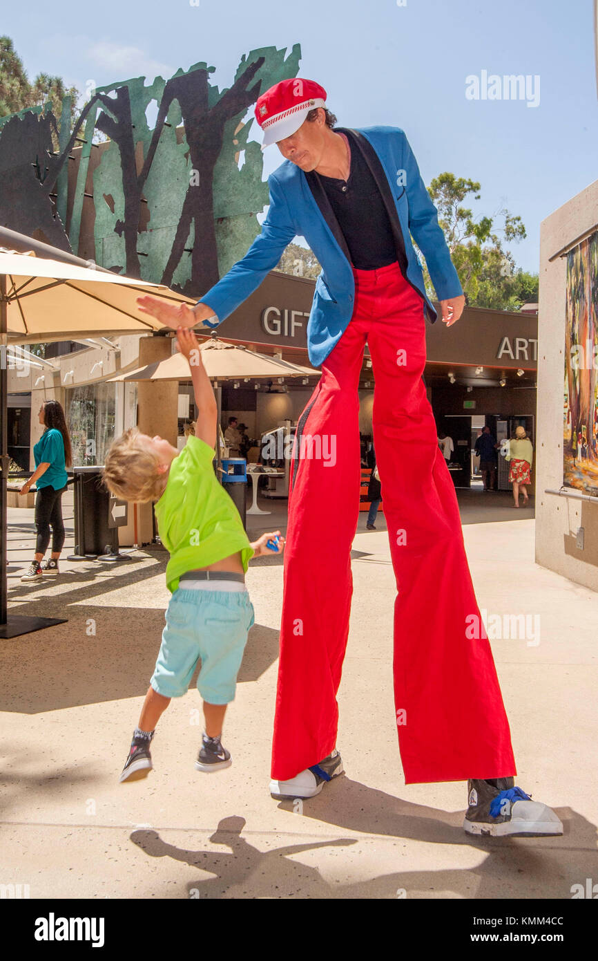 "Captain Tall Tale" stilt walker Todd McClain does a high-five with ...