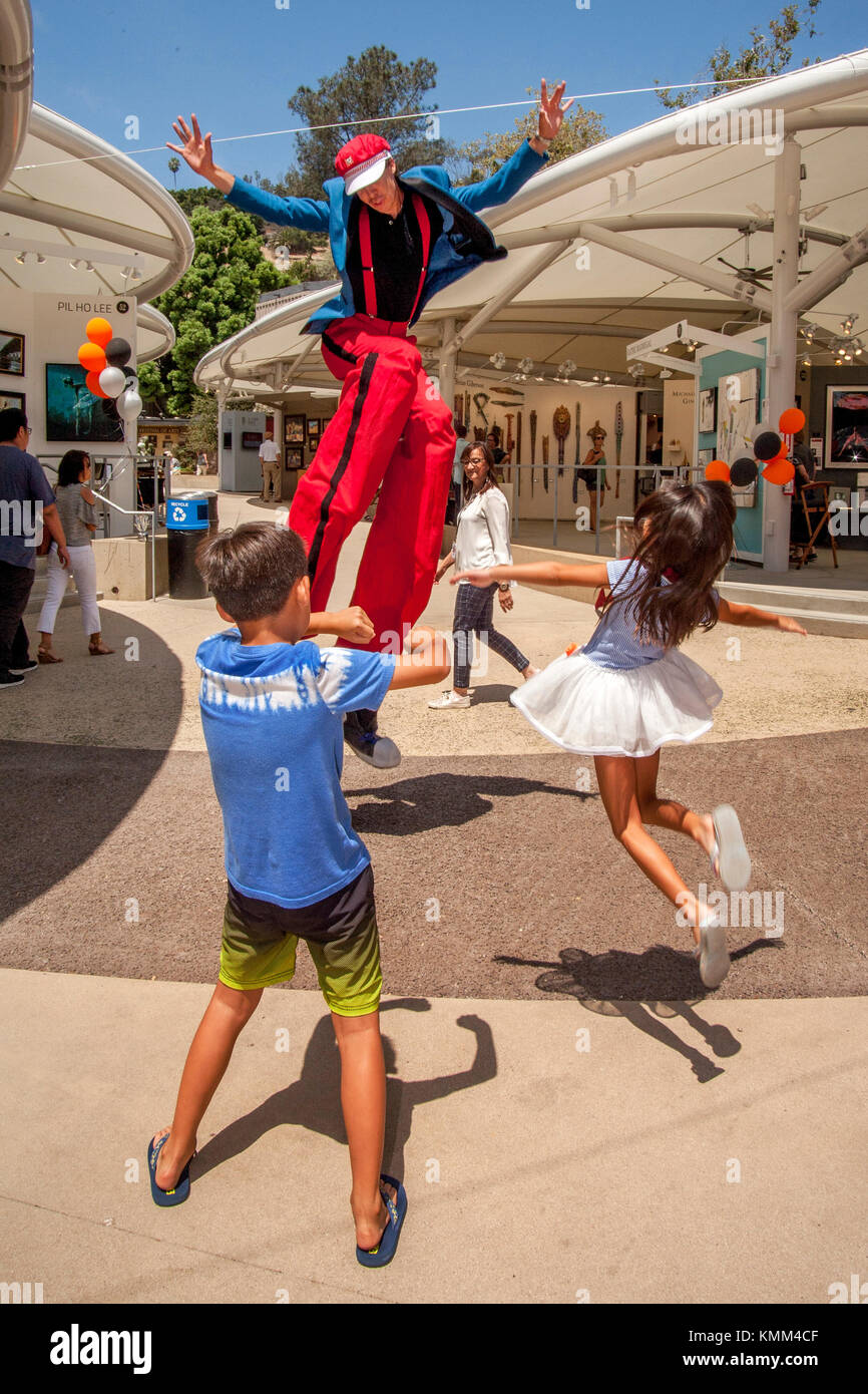 "Captain Tall Tale" stilt walker Todd McClain leads Frank Yang, 9, and ...
