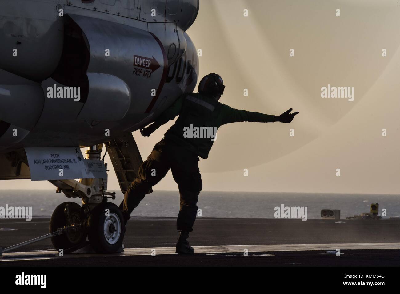 A U.S. Navy sailor prepares a U.S. Navy E-2C Hawkeye airborne early ...
