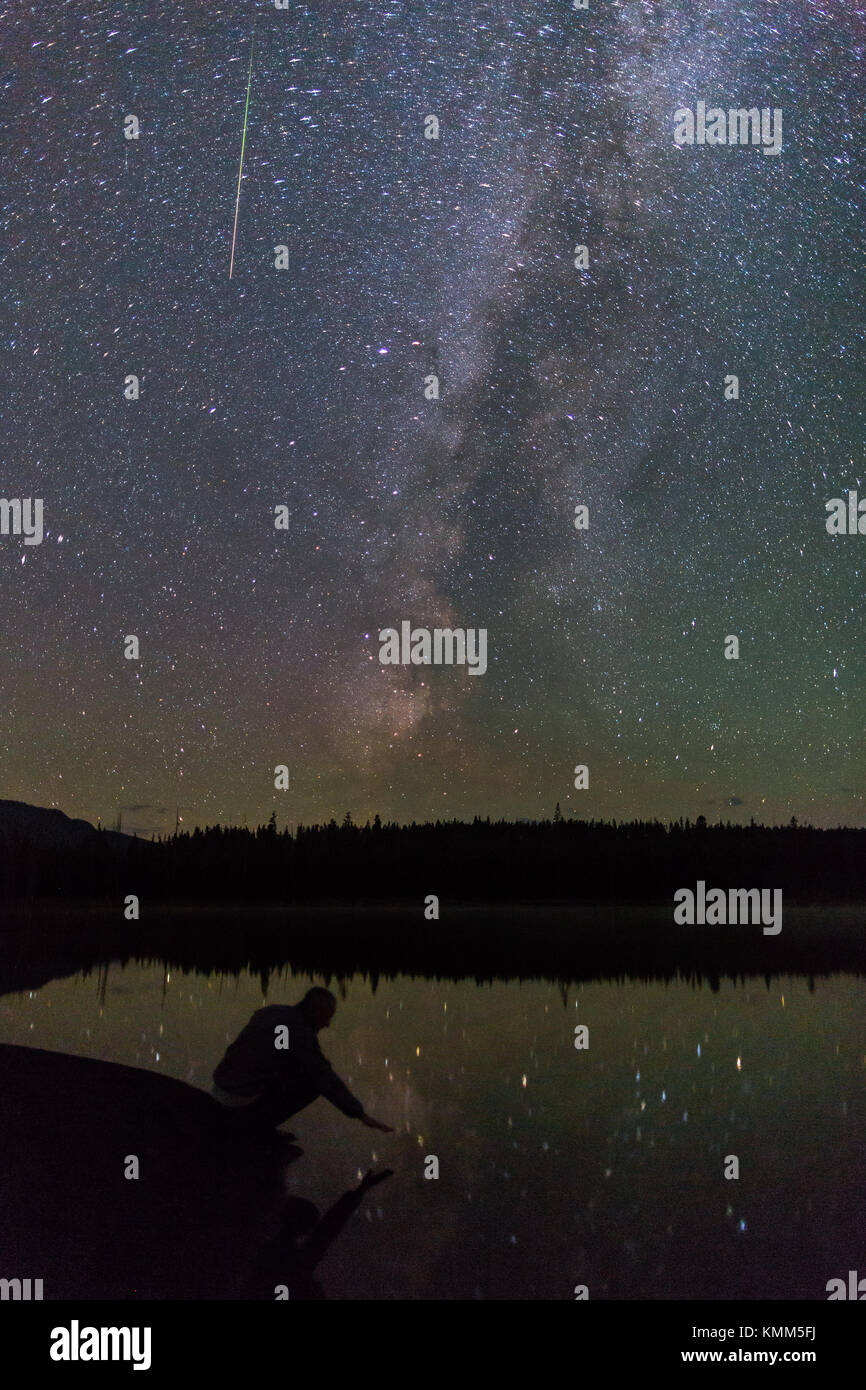 The Milky Way constellation and the starry night sky reflect off of ...