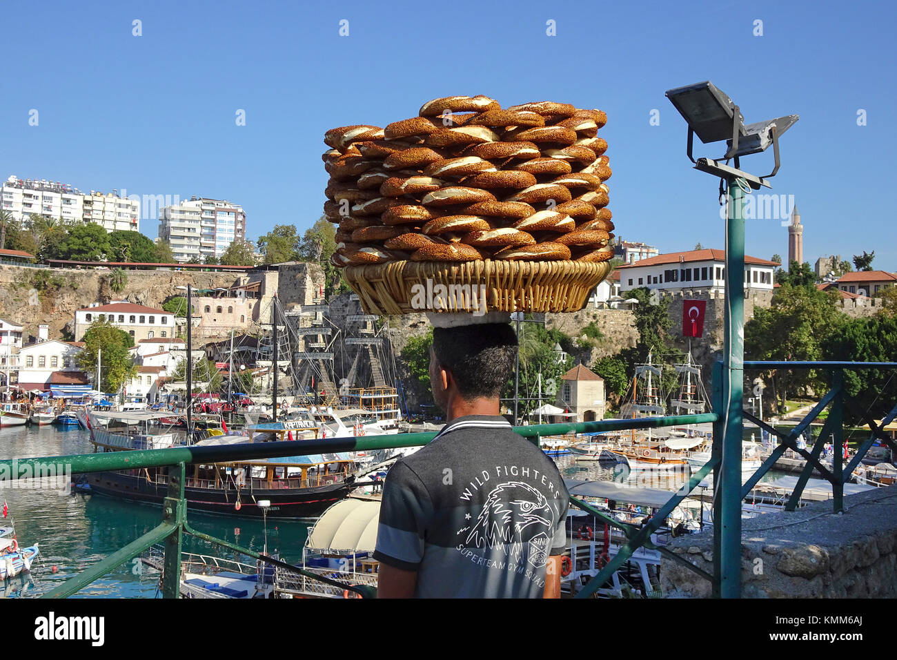 Turkish man poises simits on head, simit is similar to a bagel, covered ...