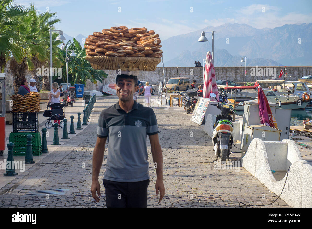 Turkish man poises simits on head, simit is similar to a bagel, covered ...