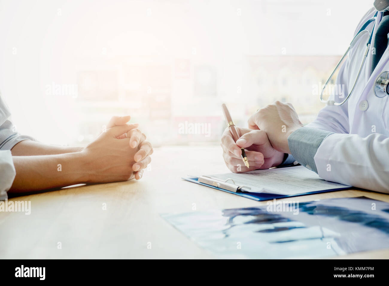 Doctors and patients sit and talk. At the table near the window in the ...