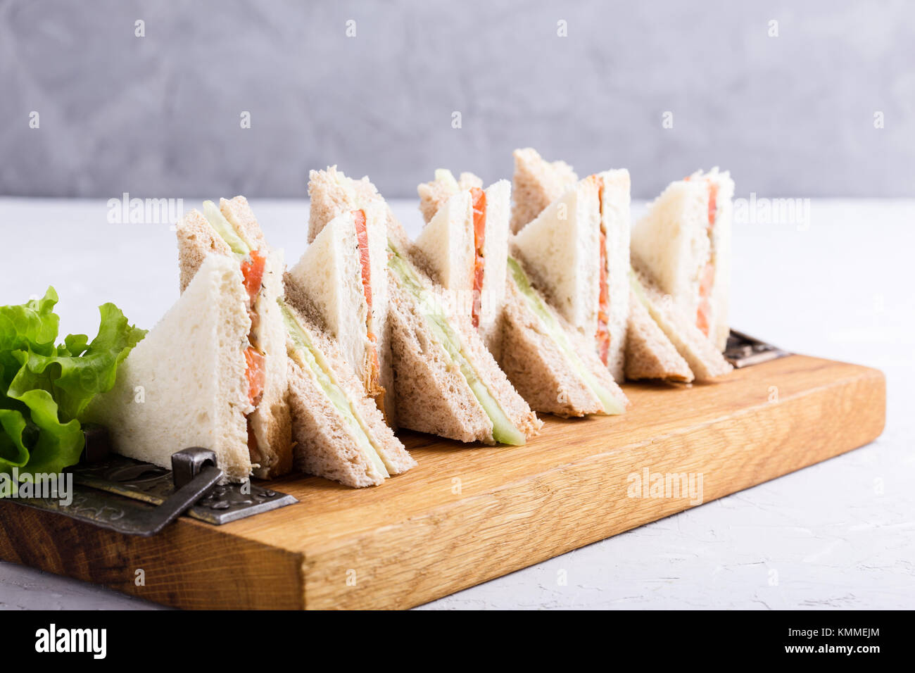 English tea sandwiches platter on wooden board over light background ...