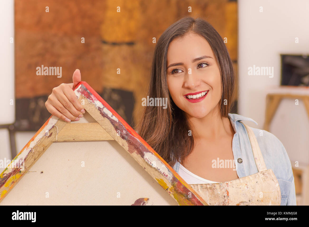 Beautiful smiling woman painter holding in her hands an empty frame in ...