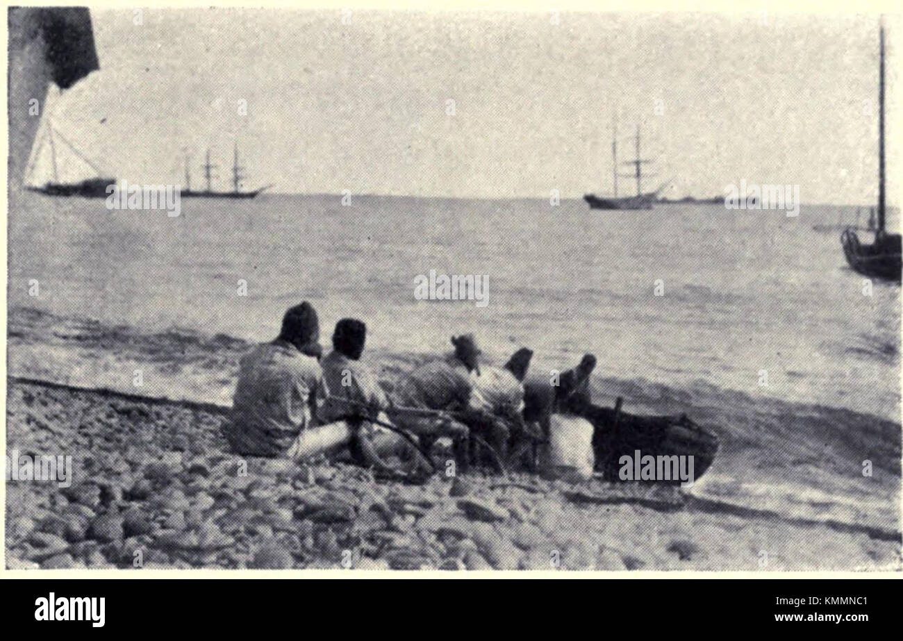 This photograph captures the action of hauling up a dinghy, likely in ...