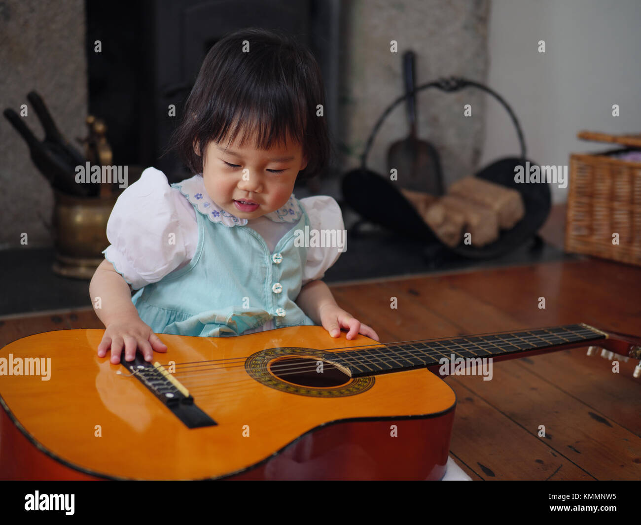 baby girl play guitar at home Stock Photo - Alamy