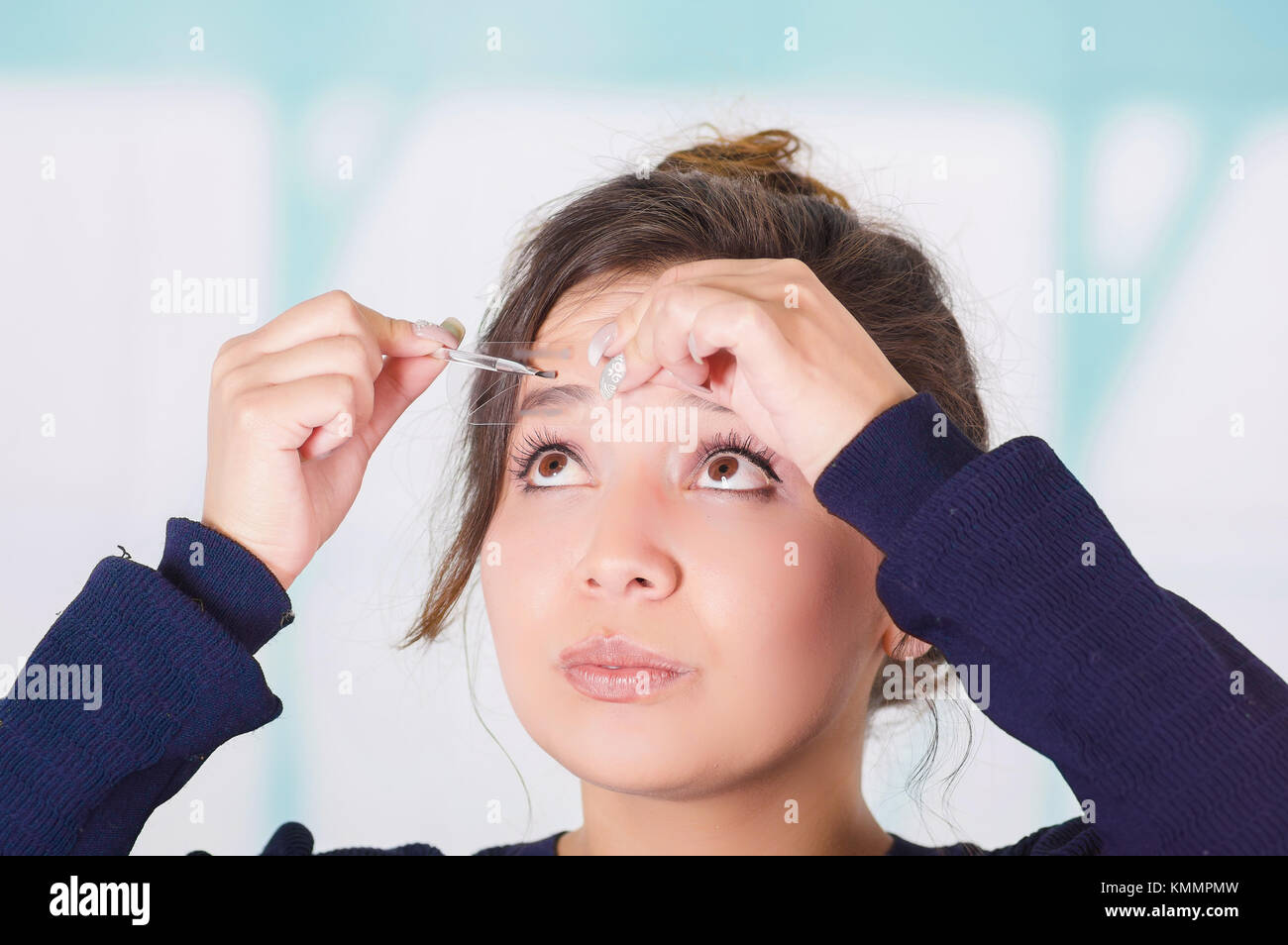 Close up of young beautiful woman doing a mess in her eyebrow in a ...