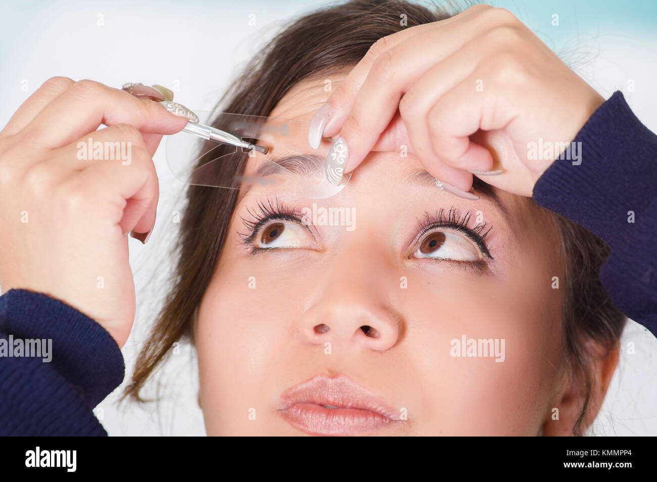 Portrait of young beautiful woman doing a mess in her eyebrow in a ...