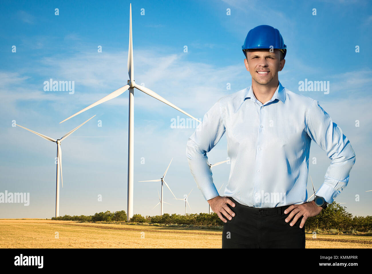 Young blue collar worker or engineer wearing in yellow helmet stands in ...