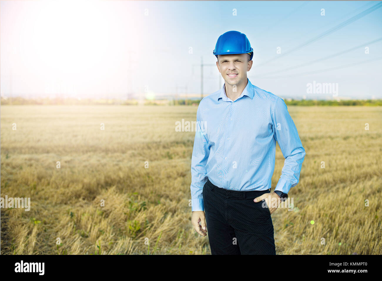 Young blue collar worker or engineer wearing in yellow helmet stands in ...
