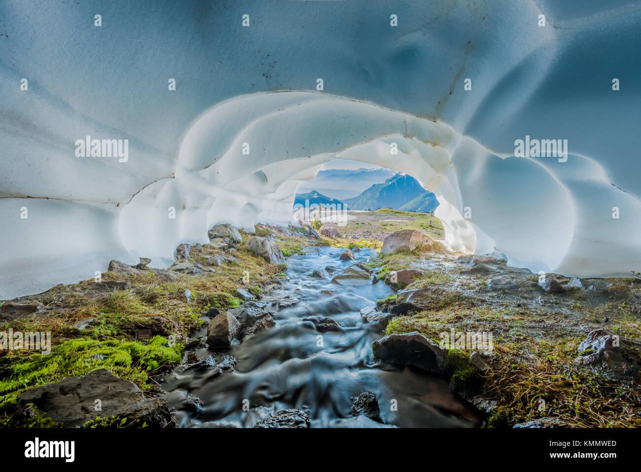 Creek Flows Through Snow Cave toward mountain view Stock Photo - Alamy