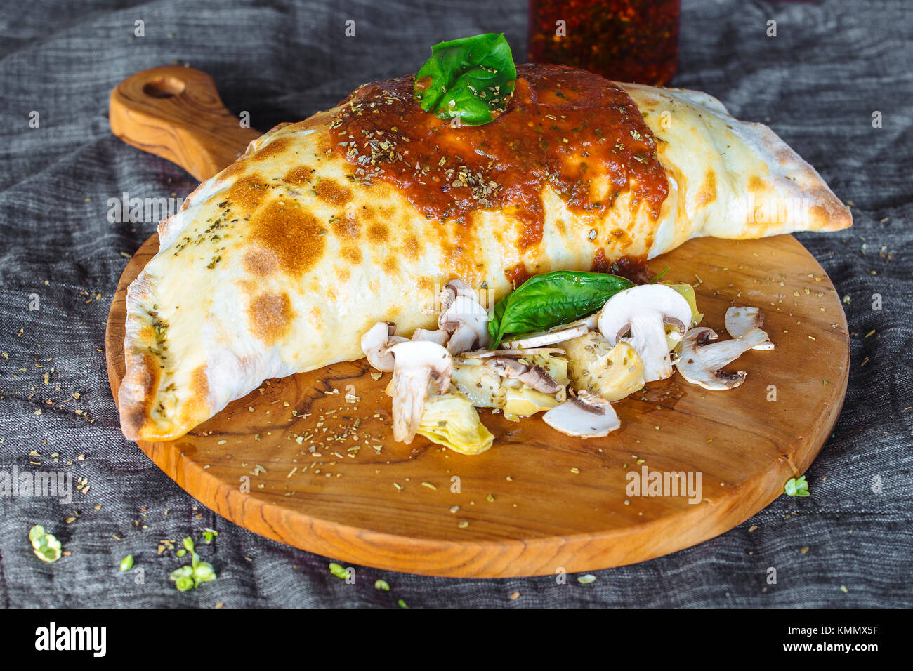 Calzone pizza, filled herbs, cheese and tomatoes Stock Photo - Alamy
