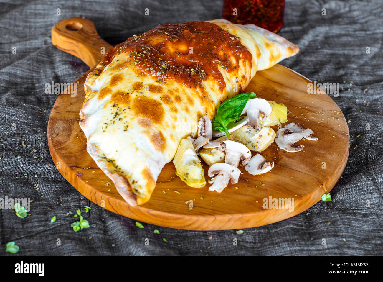 Calzone pizza, filled herbs, cheese and tomatoes Stock Photo - Alamy