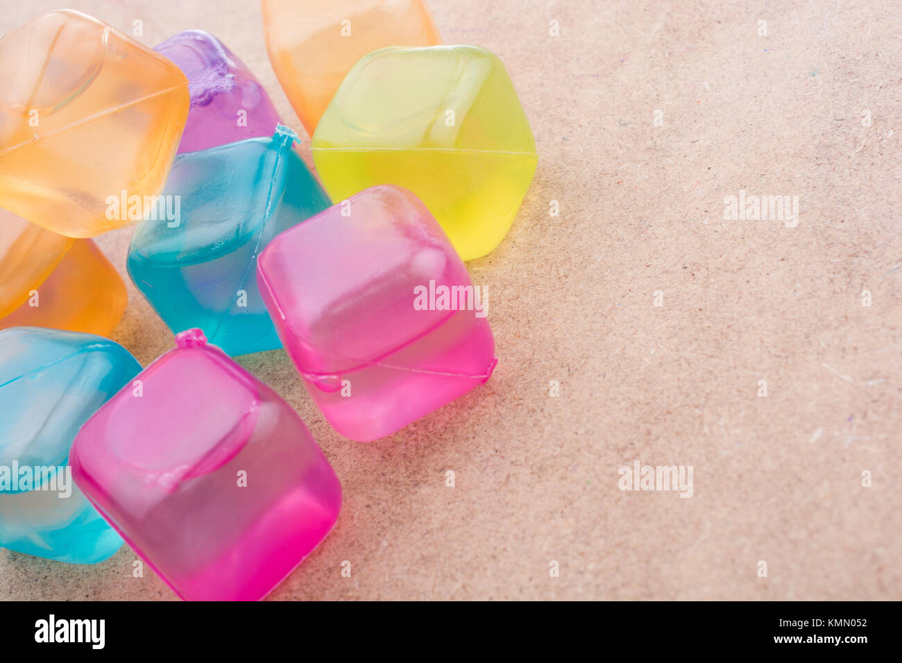 Fake colorful ice cubes on a brown background Stock Photo - Alamy