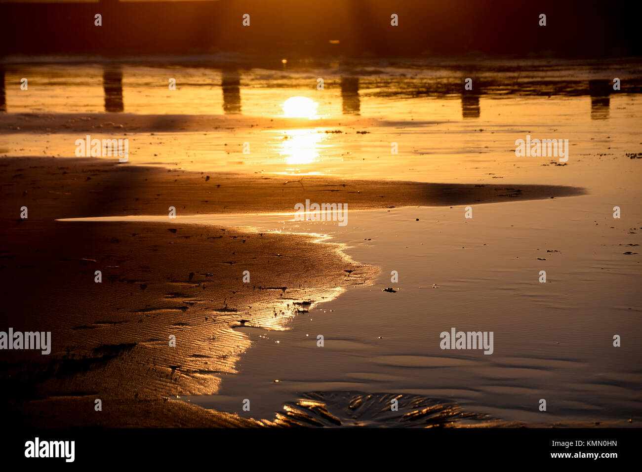 Waves and the beach at sunset Stock Photo - Alamy