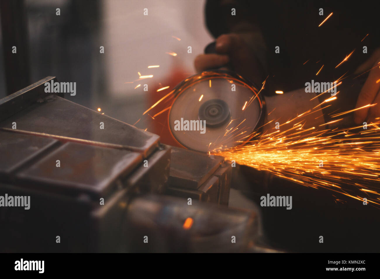 Metal workshop - worker grinding metal construction with a circular saw ...
