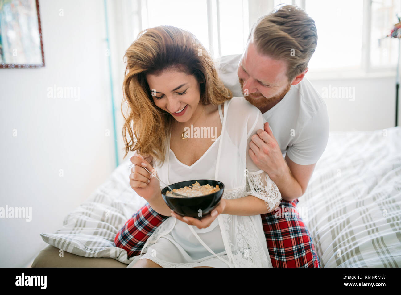 Beautiful happy couple waking up smiling in bedroom Stock Photo - Alamy