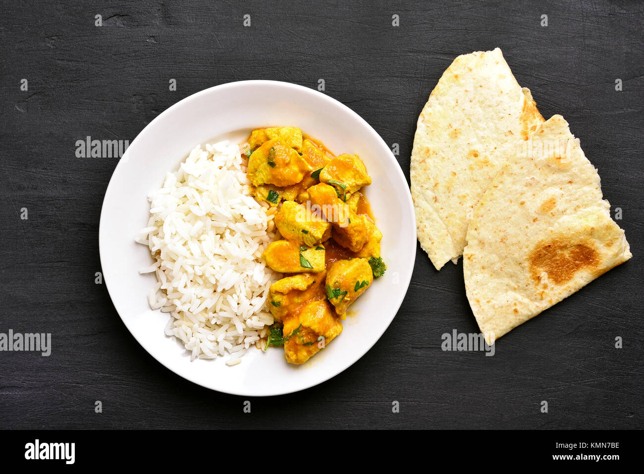 Chicken curry with rice on black stone background. Top view, flat lay ...