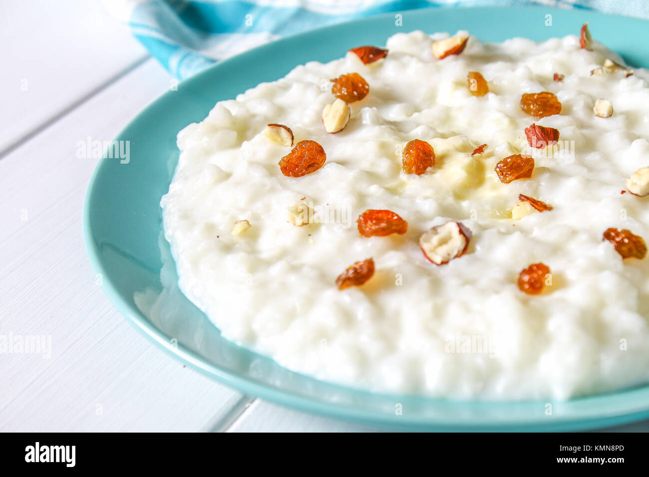 Rice milk porridge with nuts and raisins in a blue dish on a white ...