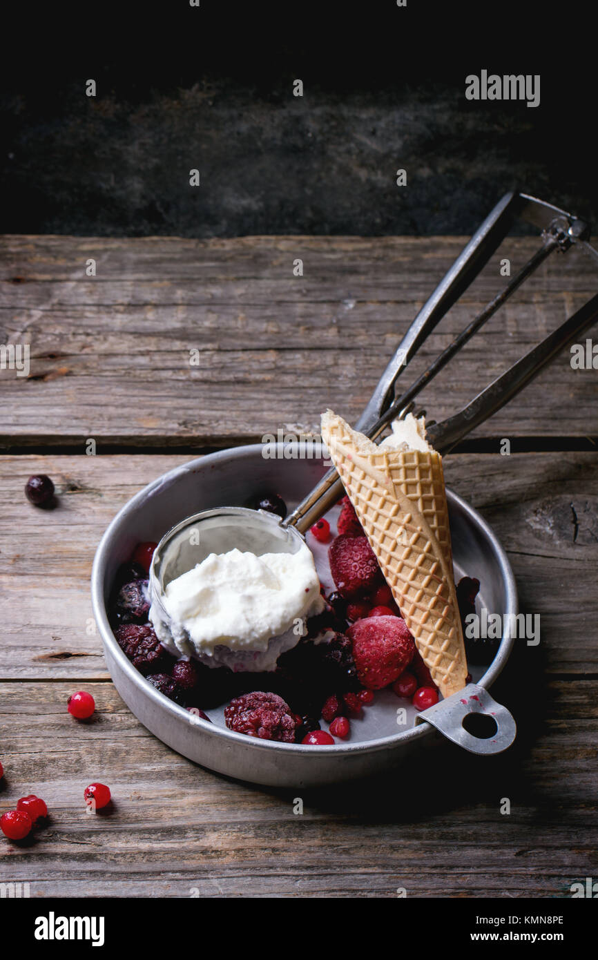 Aluminium plate with homemade vanilla ice cream, mix of frozen berries ...