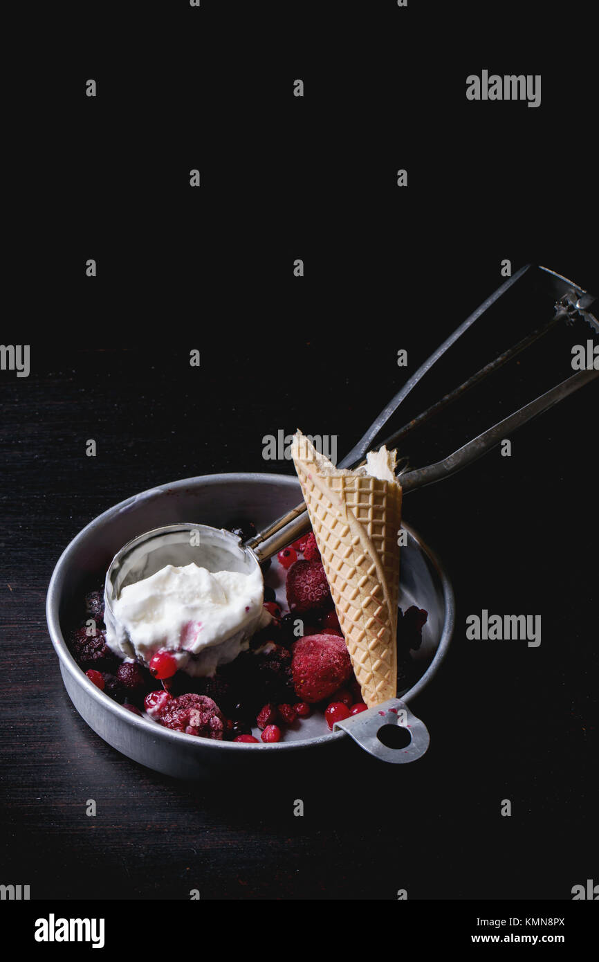 Aluminium plate with vanilla ice cream, mix of frozen berries and ...