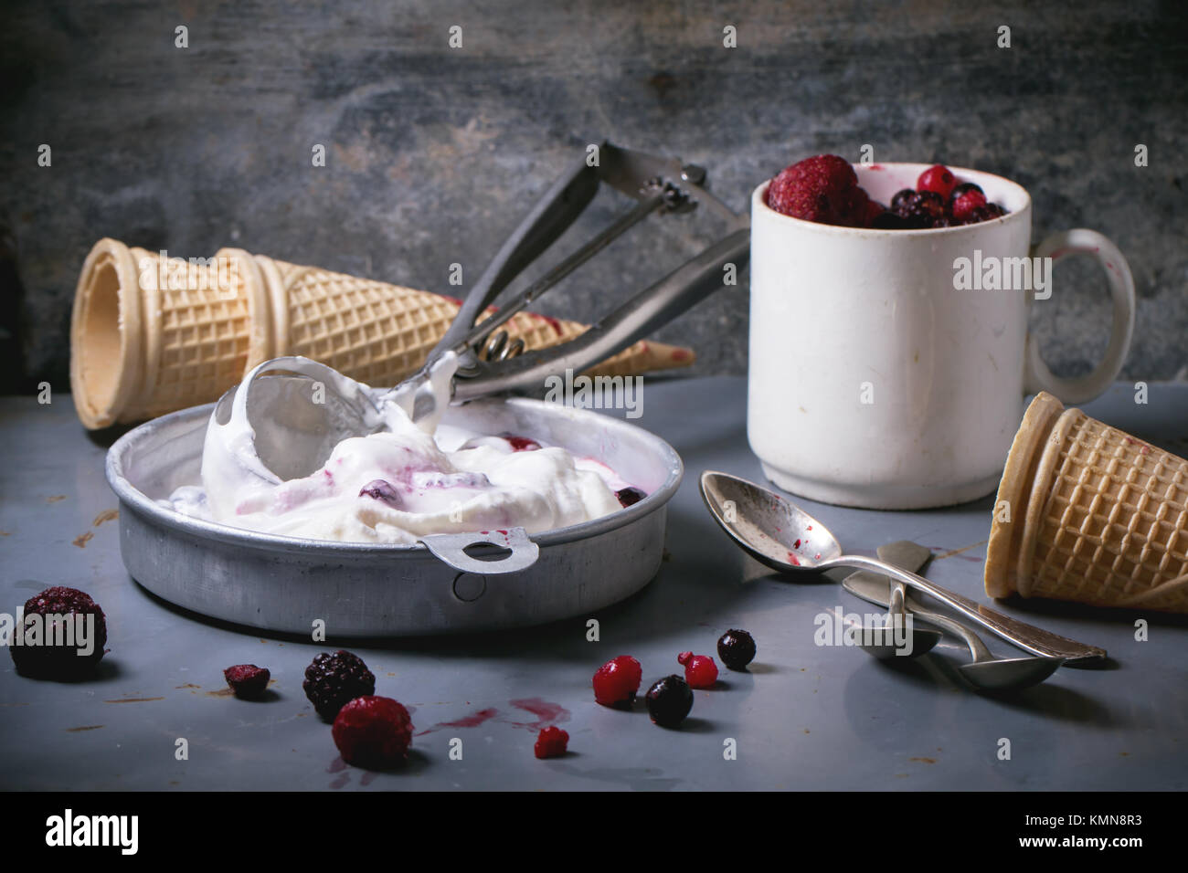 Aluminium plate with vanilla ice cream, mix of frozen berries and ...