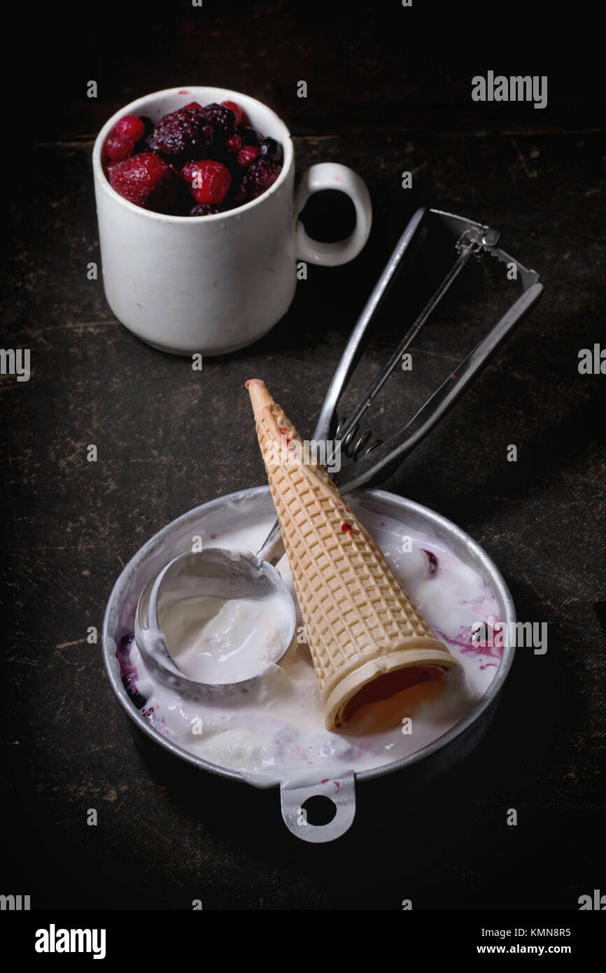 Aluminium plate with vanilla ice cream, mix of frozen berries and ...