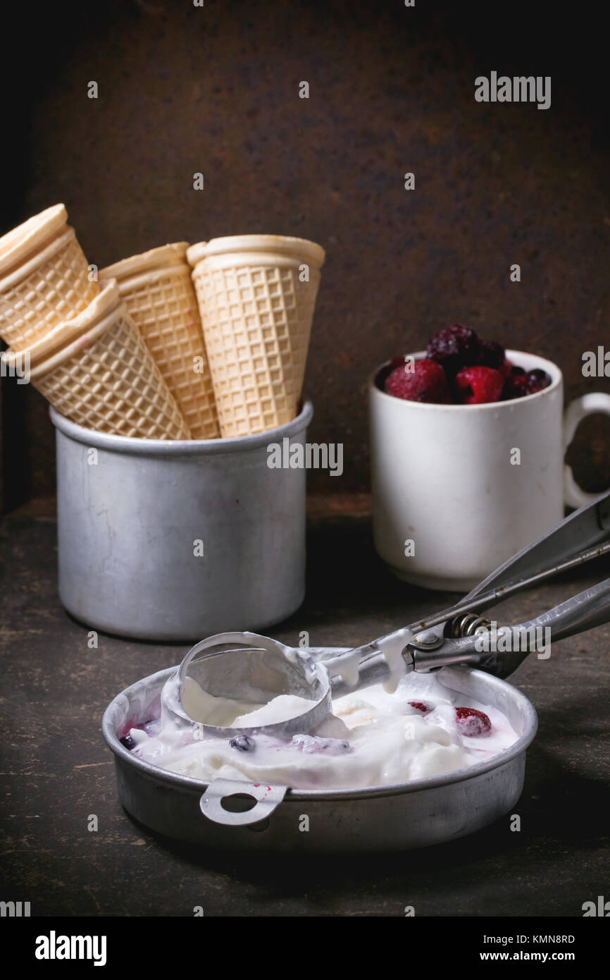 Aluminium plate with vanilla ice cream, mug of frozen berries and ...