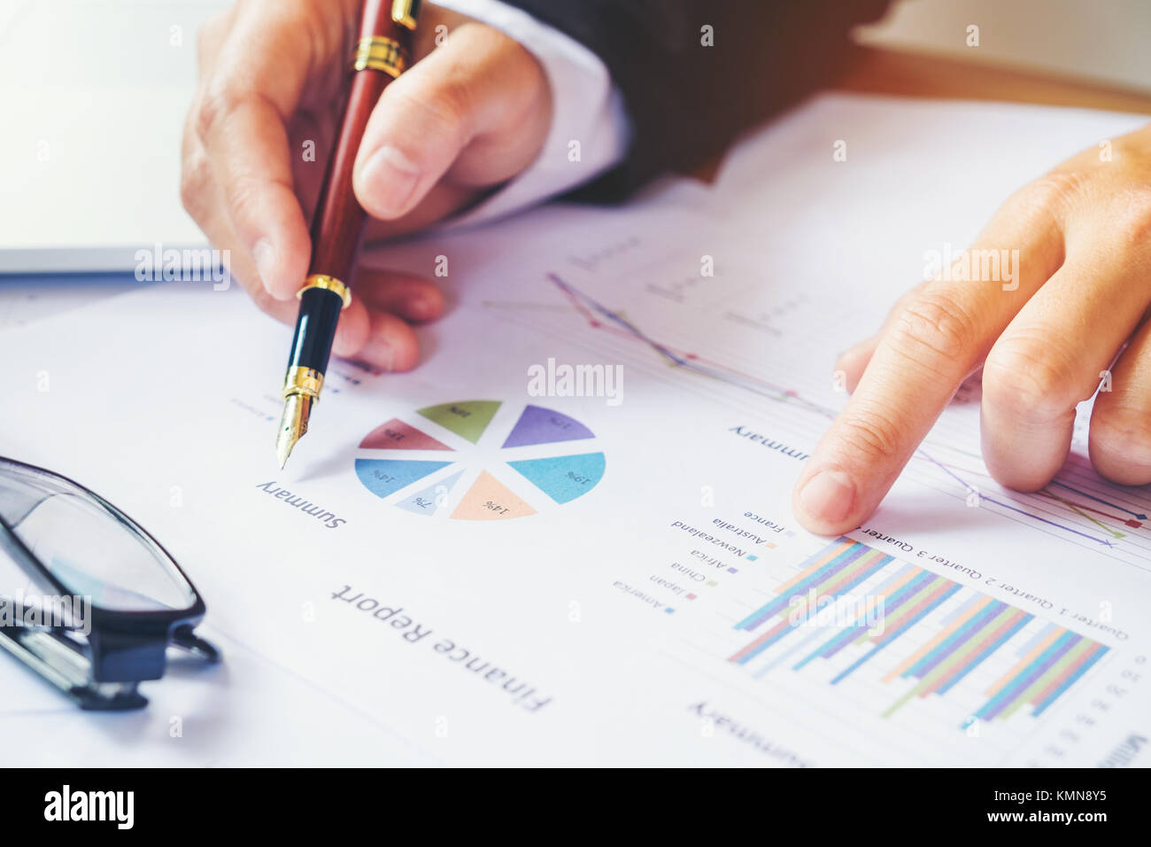 business man holding pen pointing on summary report chart Stock Photo ...