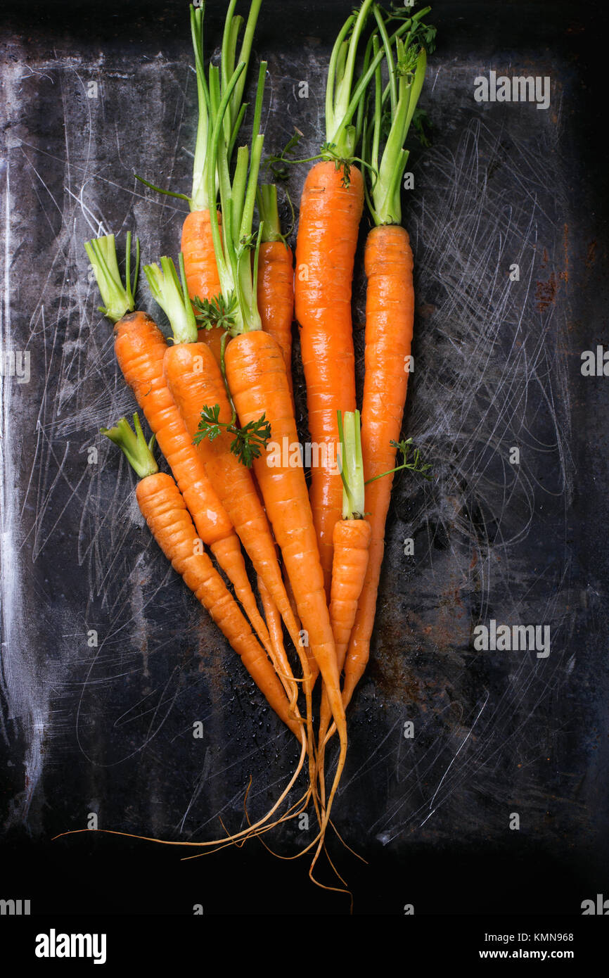 Bundle of carrots over black metal surface. Top view Stock Photo - Alamy
