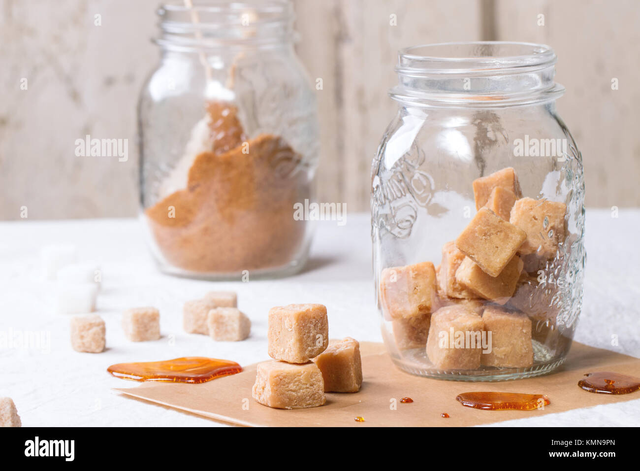 Fudge candy and caramel on baking paper and in glass jar, served over ...