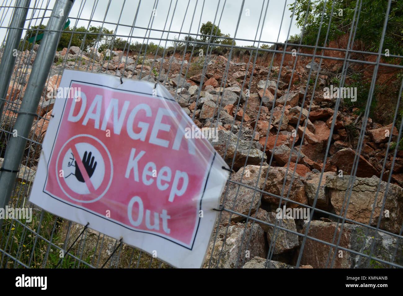 A Danger Kepp out sign on a fence with rubble in background Stock Photo ...