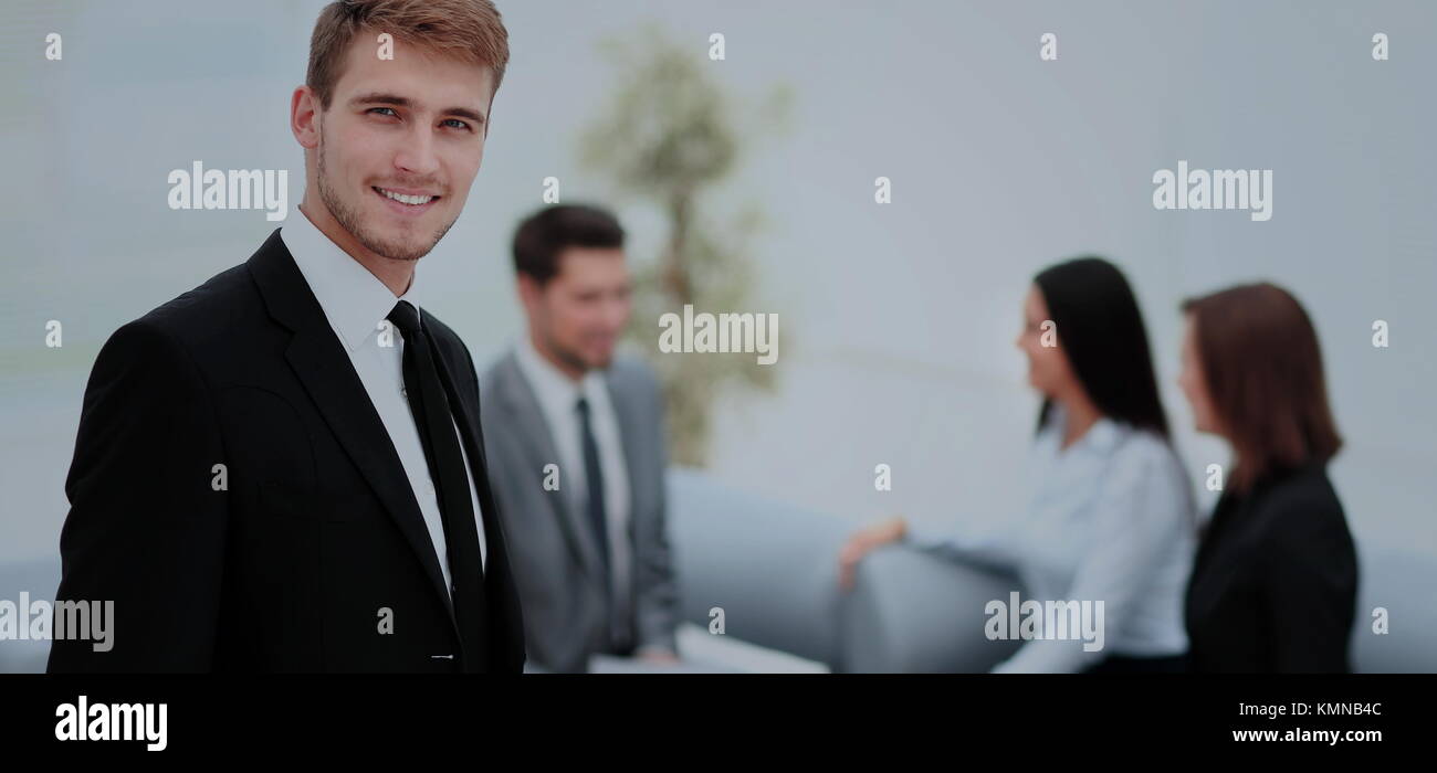 Successful business man standing with his staff in background at Stock ...